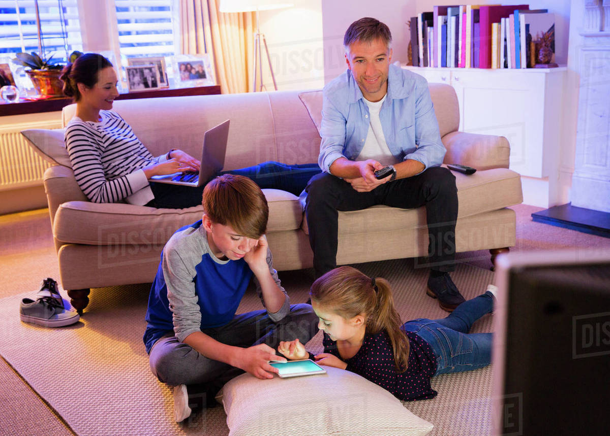 Family relaxing with technology in living room - Royalty-free Stock ...