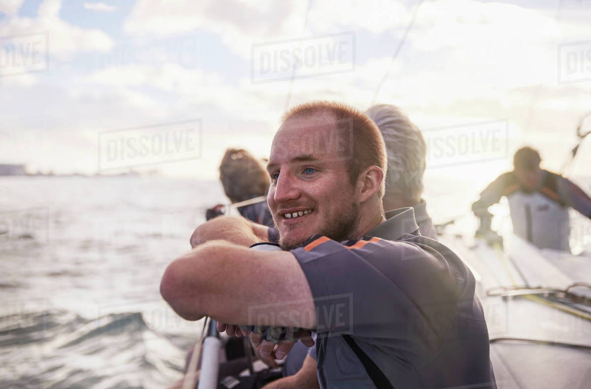 Smiling man sailing on sailboat - Stock Photo - Dissolve