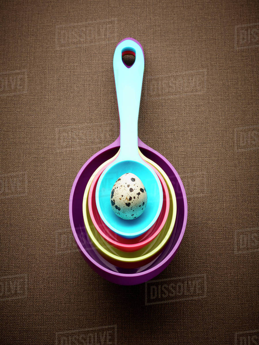 Spotted egg in multicolor nesting measuring spoons - Stock Photo - Dissolve