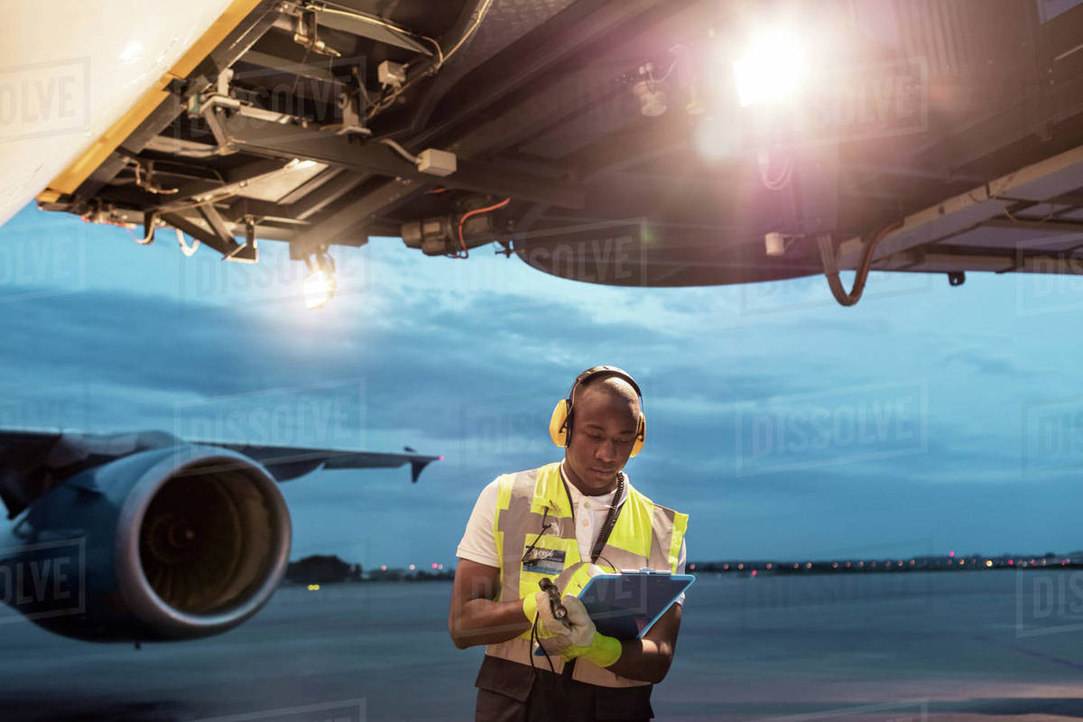 Airport ground crew worker with clipboard under airplane on tarmac ...