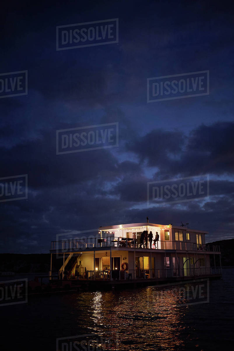 Summer houseboat illuminated on night ocean - Royalty-free Stock Photo ...