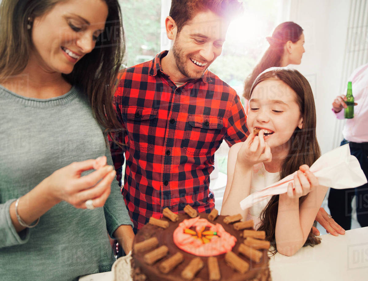 Family icing and decorating chocolate cake - Royalty-free Stock Photo ...