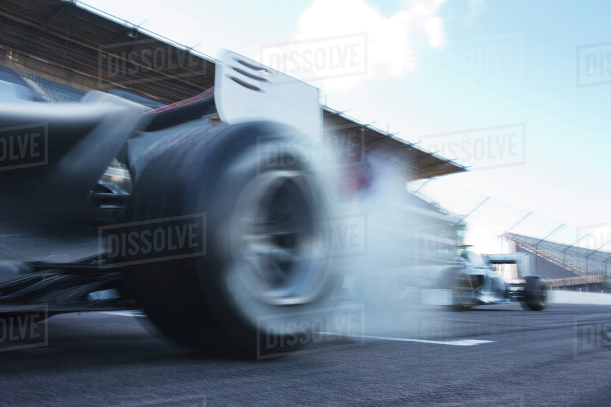 Race cars driving on track - Stock Photo - Dissolve