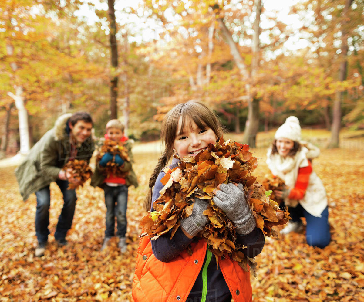 Family playing in autumn leaves - Royalty-free Stock Photo | Dissolve