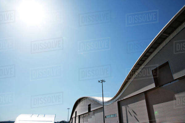 Curved roof of warehouse and blue sky - Royalty-free Stock Photo | Dissolve