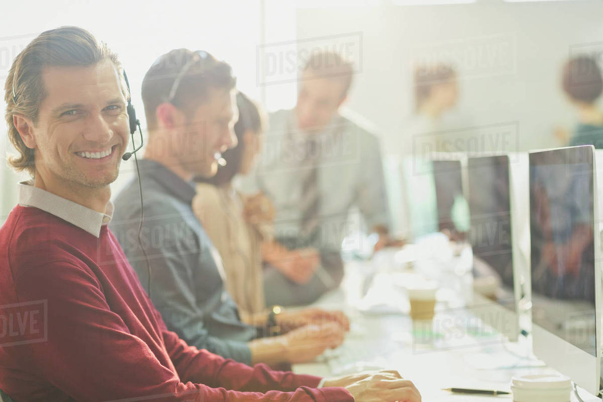 Portrait smiling telemarketer talking on telephone with headset at ...