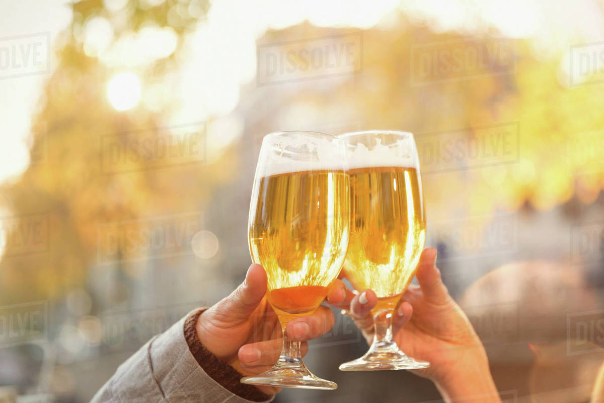Close up couple toasting beer glasses at autumn cafe - Royalty-free ...