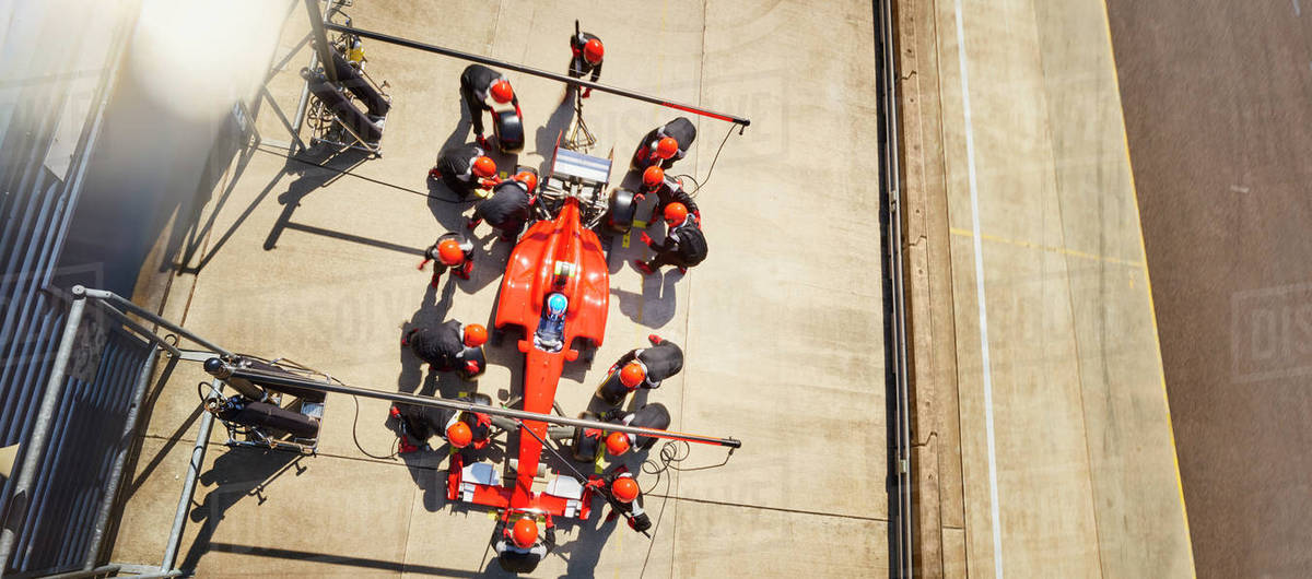 Overhead pit crew working on formula one race car in pit lane - Royalty ...