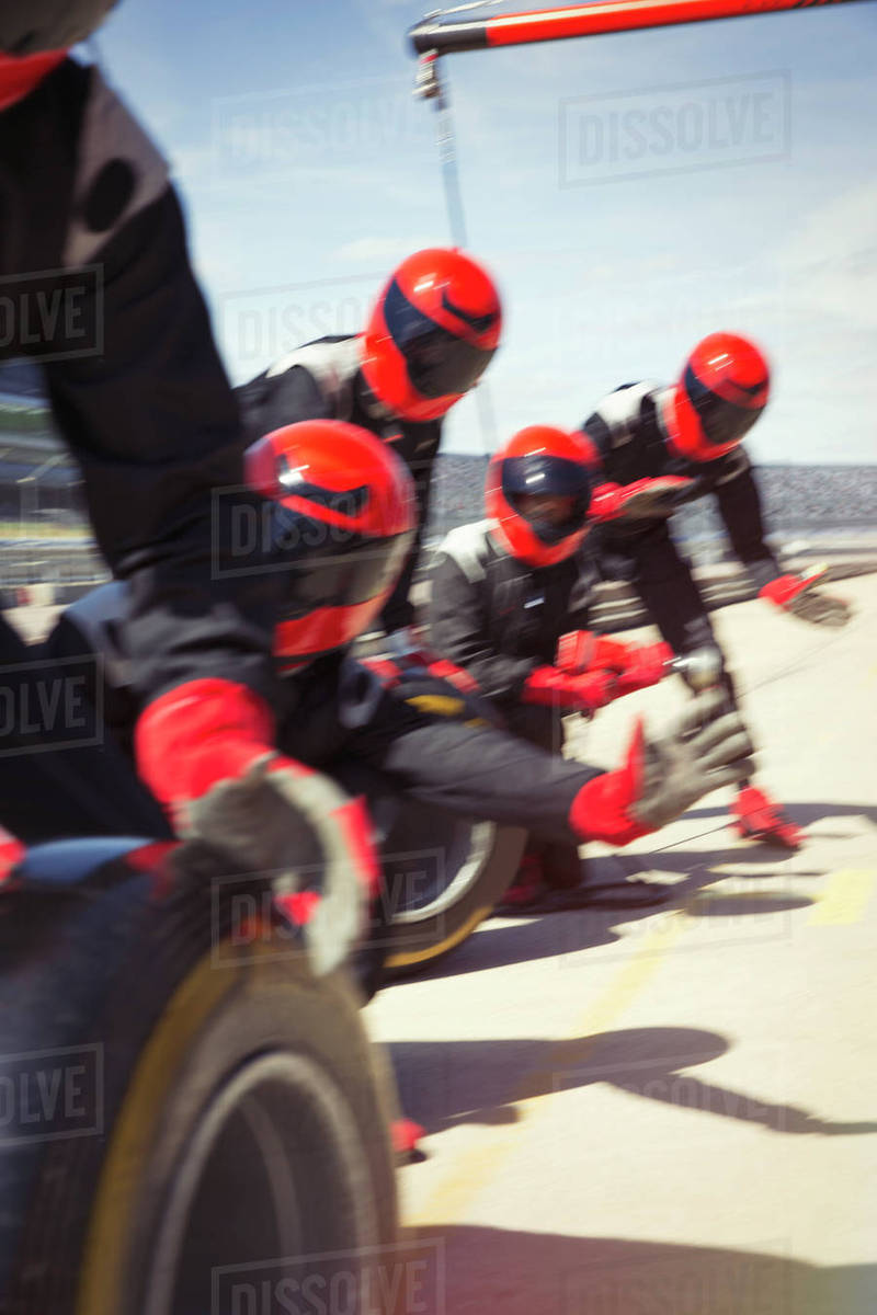 Pit crew with tires ready in pit lane - Stock Photo - Dissolve