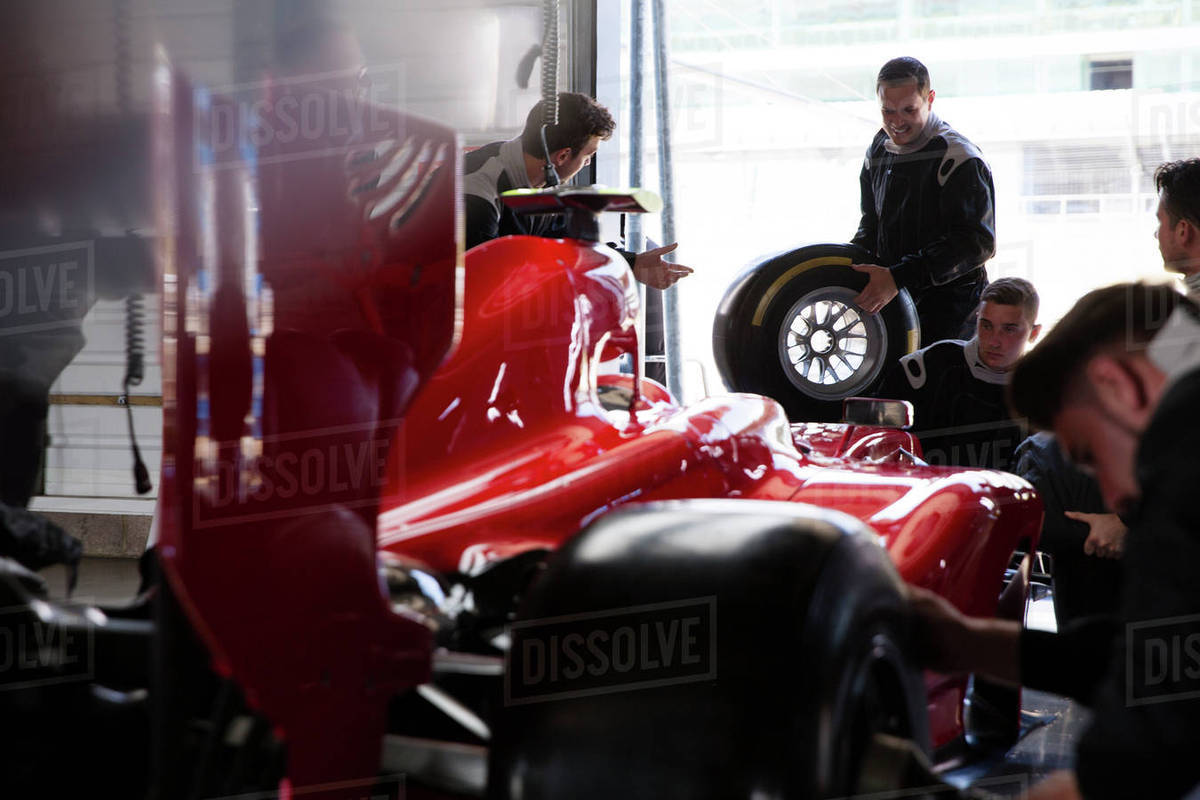 Pit crew working on formula one race car in repair garage - Royalty-free Stock Photo | Dissolve