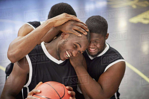 Happy young male basketball players hugging and celebrating after ...