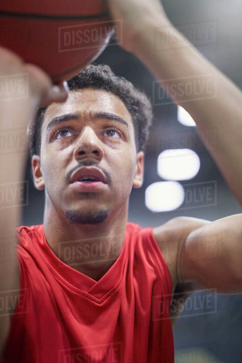 Close up focused young male basketball player shooting free throw ...