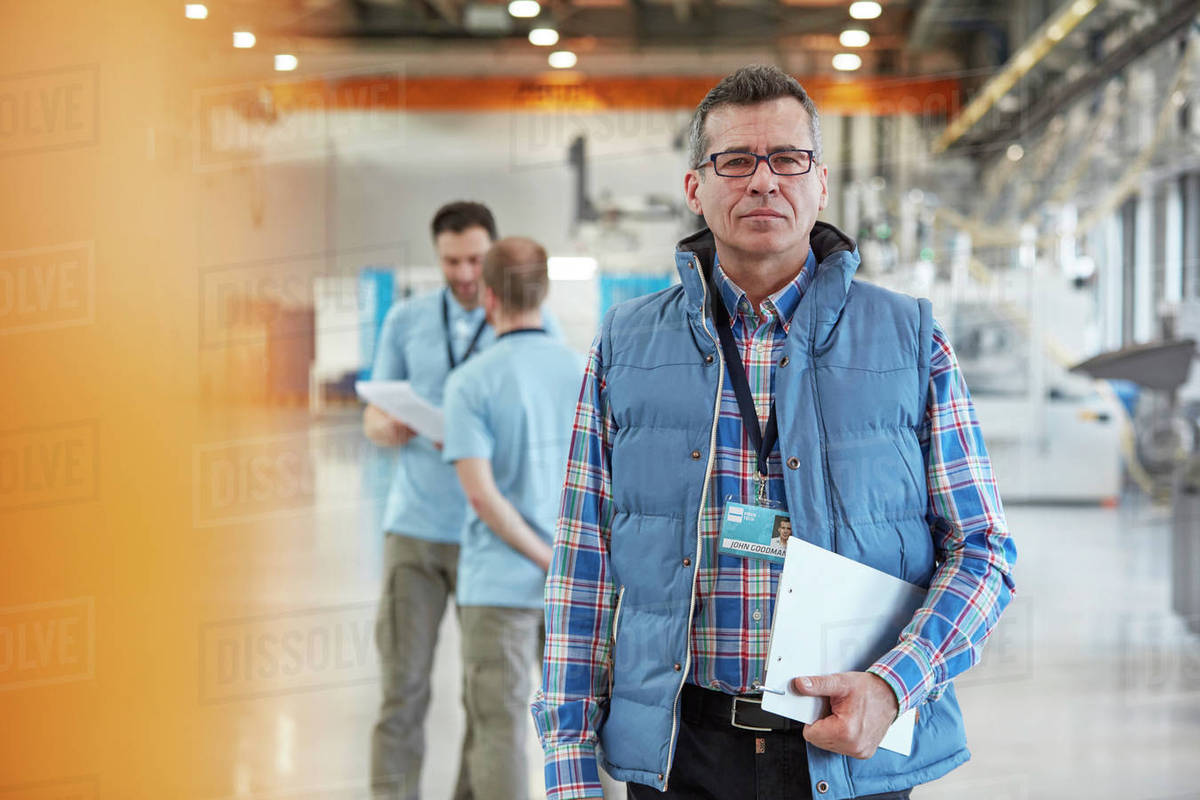Portrait confident male supervisor with clipboard in factory - Royalty ...