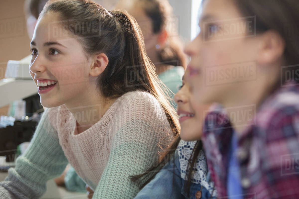 Curious, smiling girl students listening in classroom - Royalty-free ...
