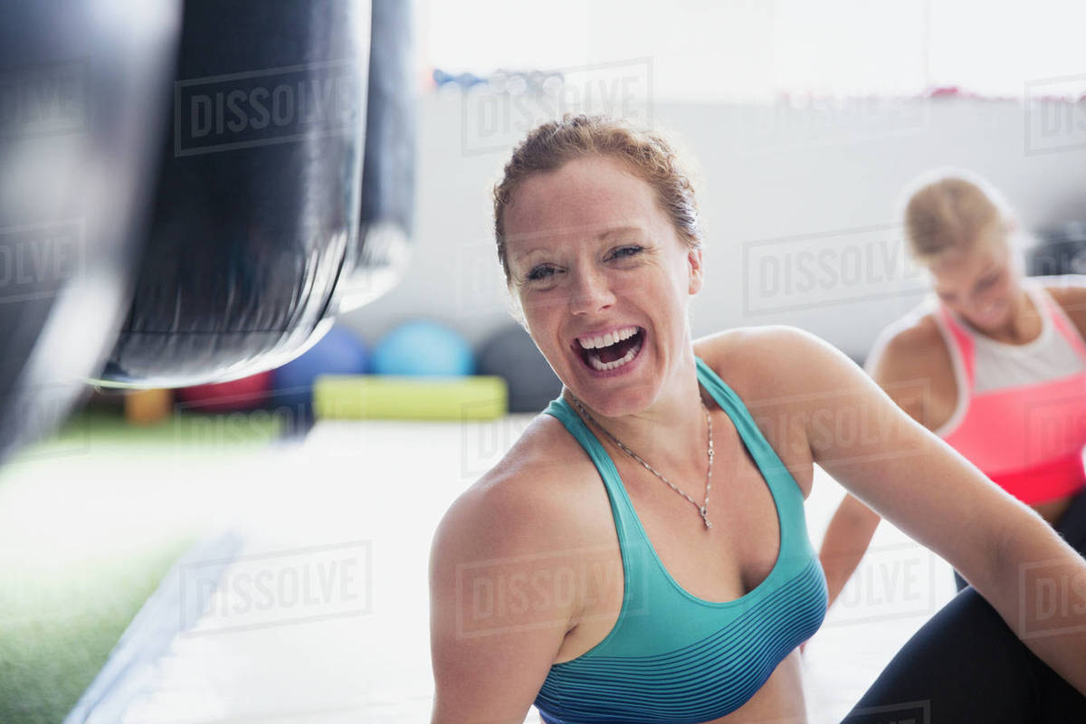 Portrait laughing female boxer stretching in gym - Stock Photo - Dissolve