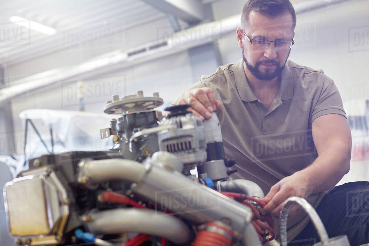 Male mechanic fixing engine - Royalty-free Stock Photo | Dissolve