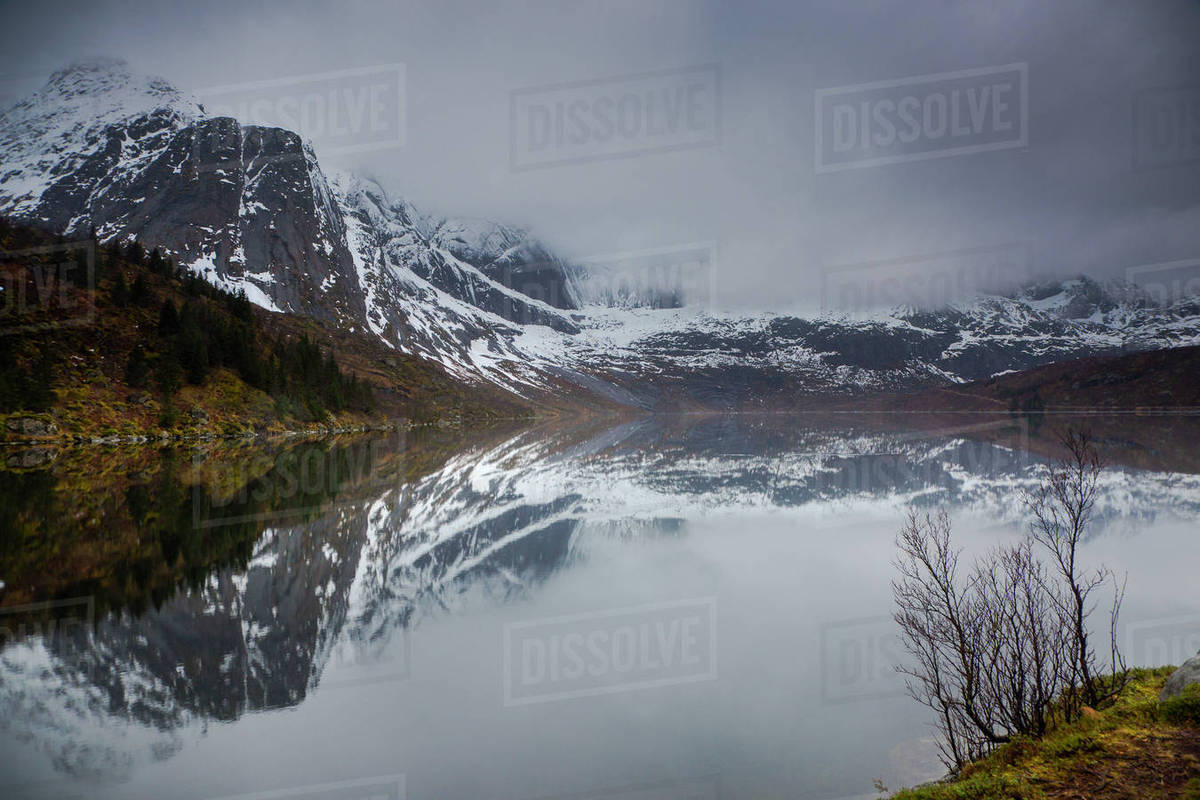 Reflection of snowy, rugged mountains in water, Storvatnet, Lofoten ...