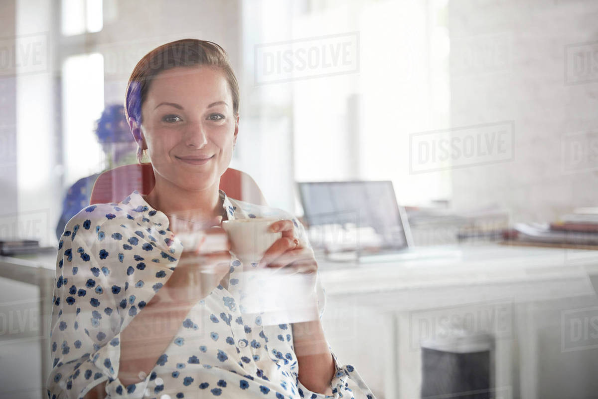Portrait smiling businesswoman drinking coffee in office - Royalty-free ...