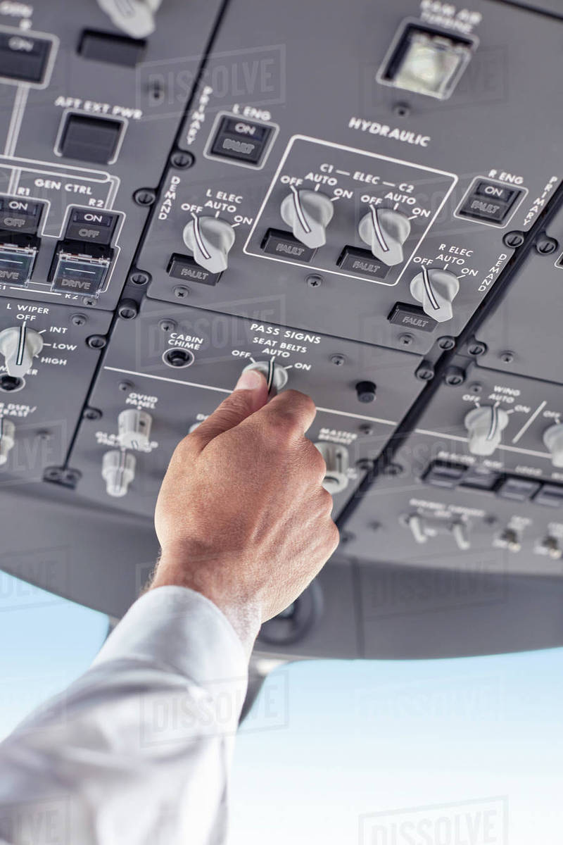 Pilot adjusting control instruments in airplane cockpit - Stock Photo ...