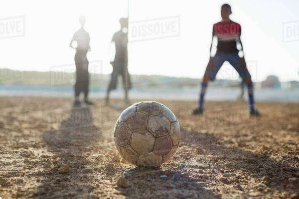 Boys playing soccer together in dirt field - Royalty-free Stock Photo ...