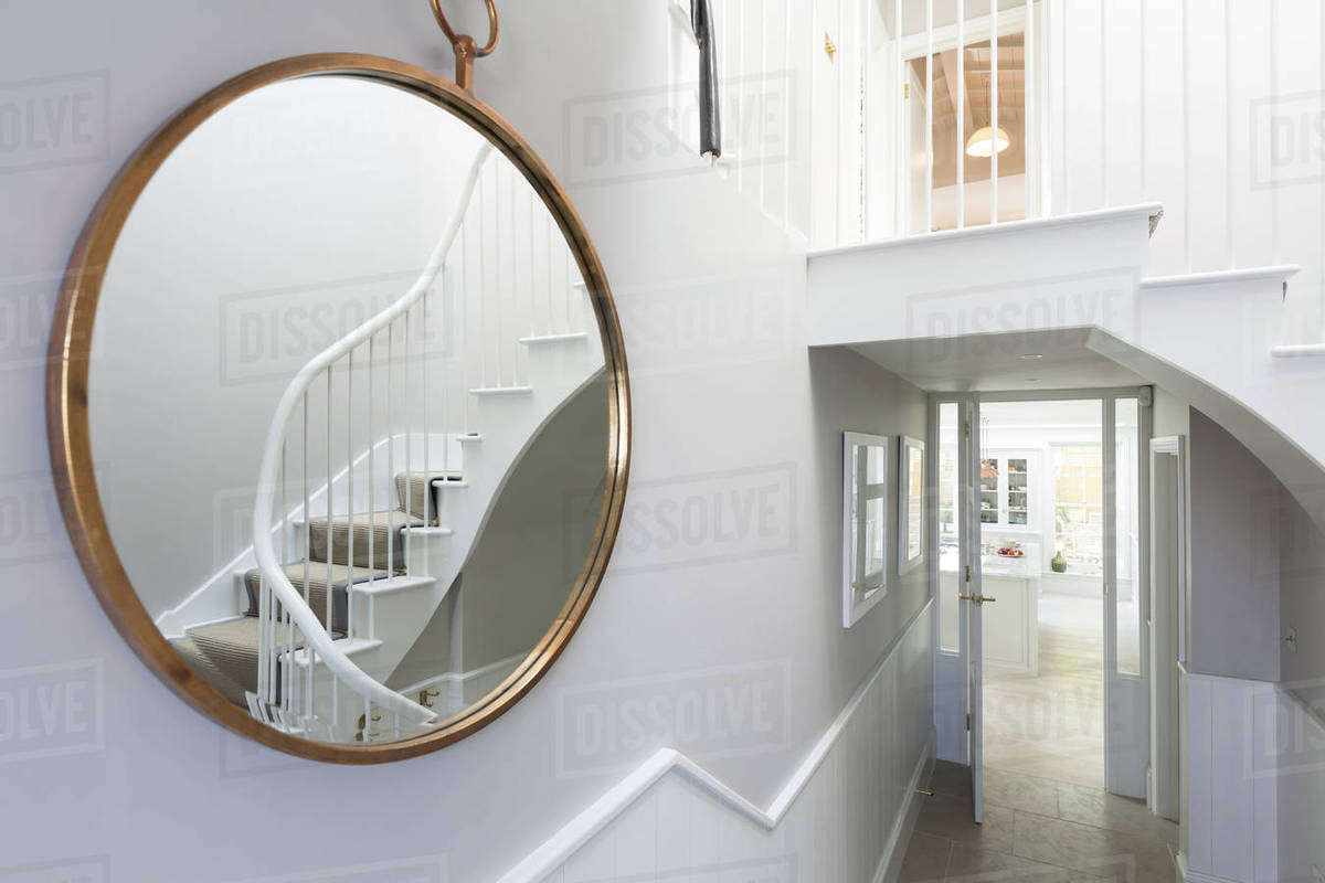 Reflection of foyer staircase in round mirror - Stock Photo - Dissolve