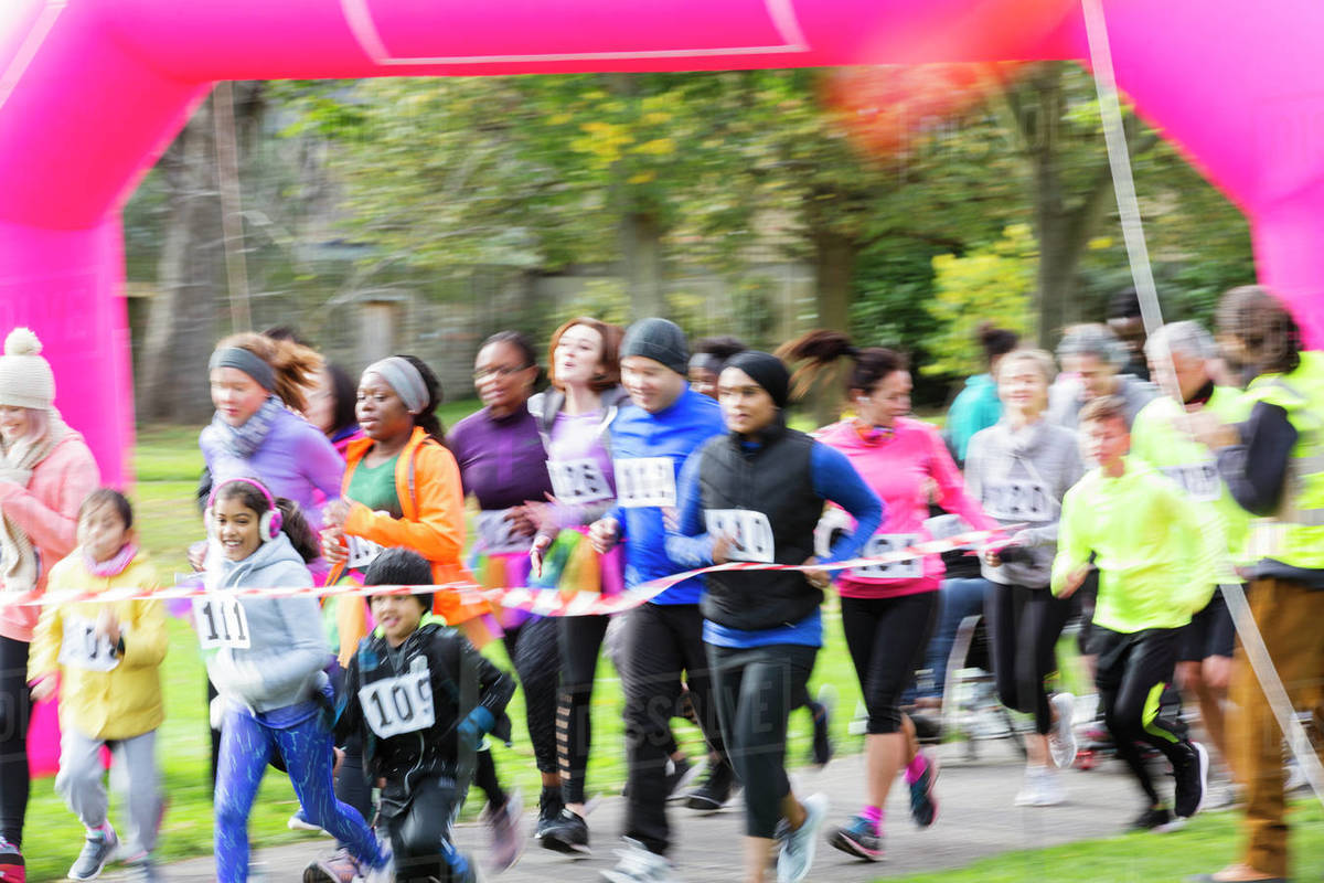 Runners crossing finish line at charity run in park - Royalty-free ...