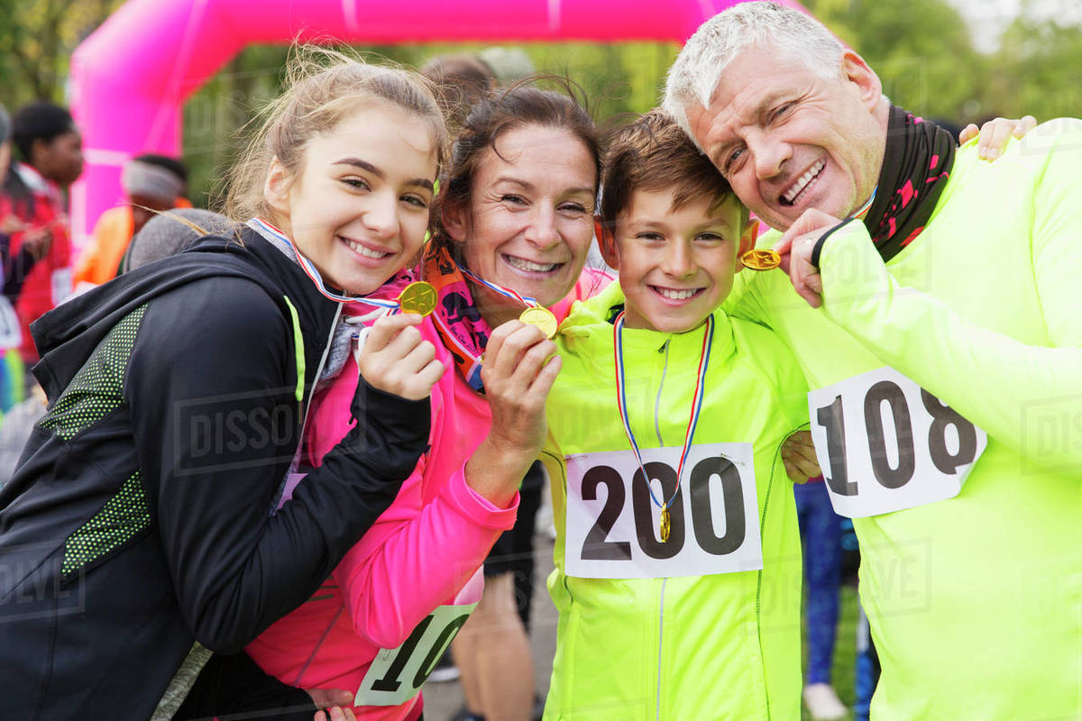 Portrait smiling, confident family runners showing medals at charity ...