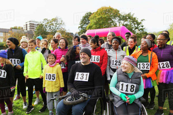 Smiling crowd at charity race in park - Stock Photo - Dissolve