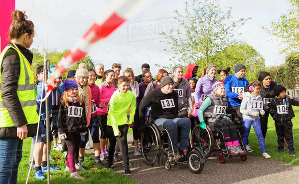 Crowd of runners and people in wheelchairs waiting at charity race ...