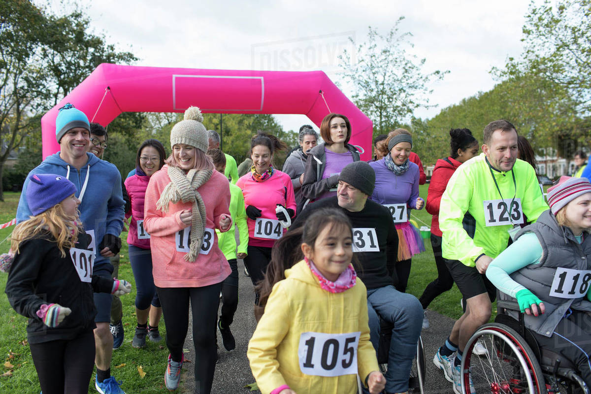Crowd running at charity run in park - Royalty-free Stock Photo | Dissolve