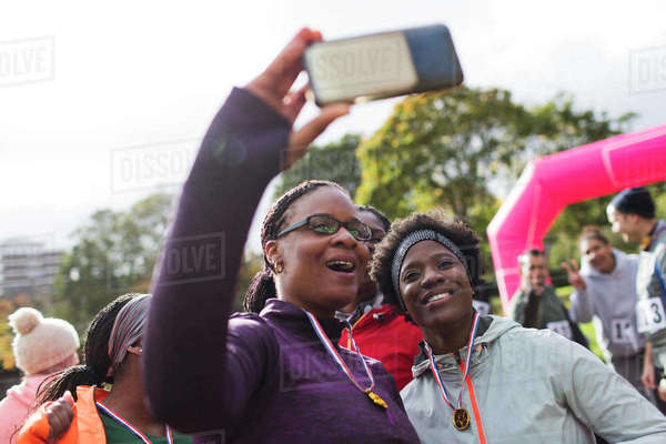 Female runner friends taking selfie at charity run in park - Stock ...