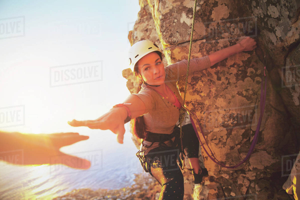 Female rock climber reaching for helping hand - Royalty-free Stock ...