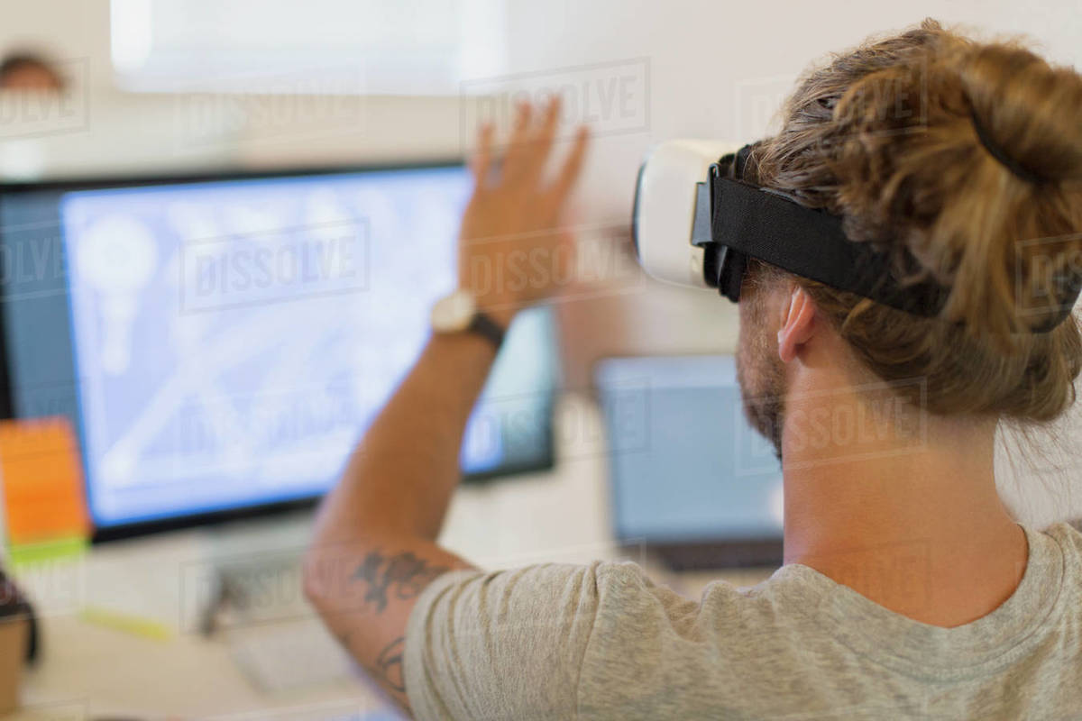 Computer programmer testing virtual reality simulator glasses at ...