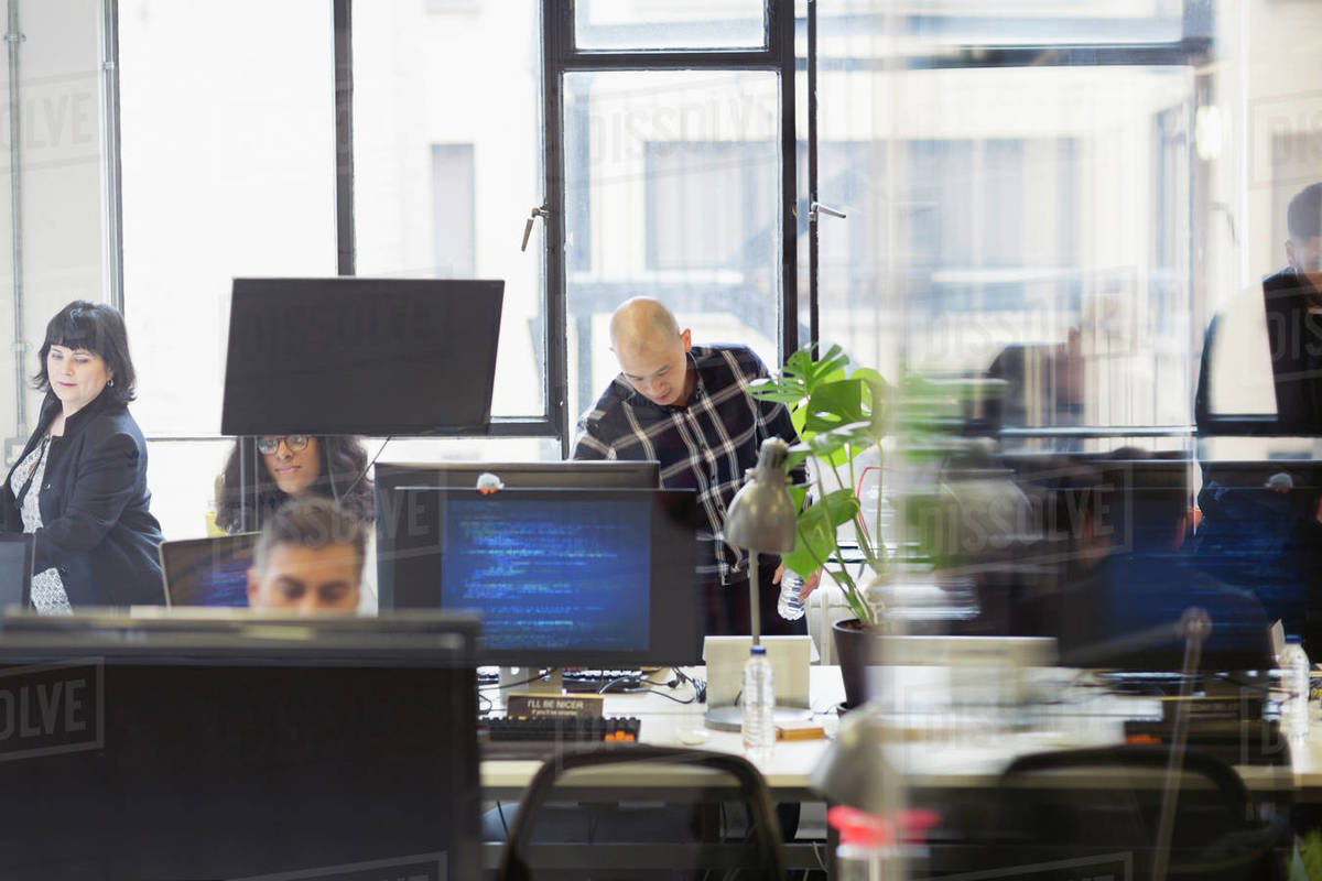 Business people working in open plan office - Stock Photo - Dissolve