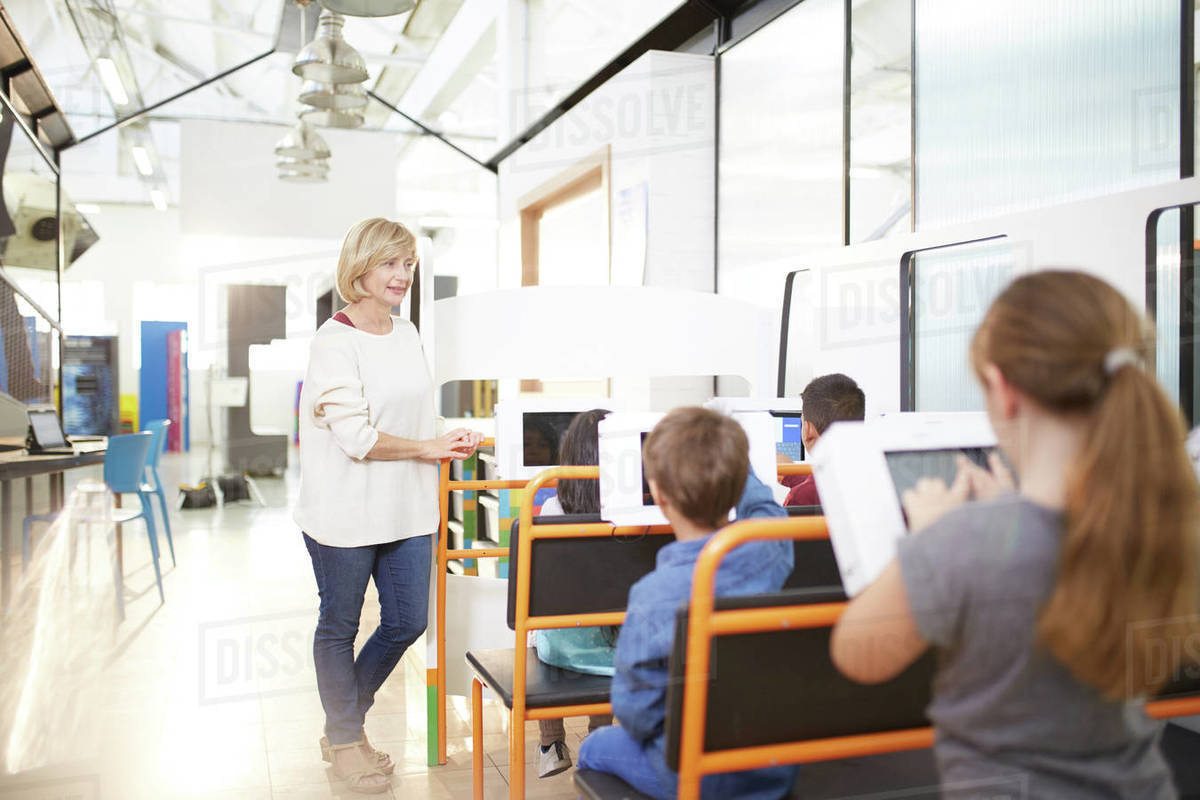 Teacher and students using touch screen computers - Stock Photo - Dissolve