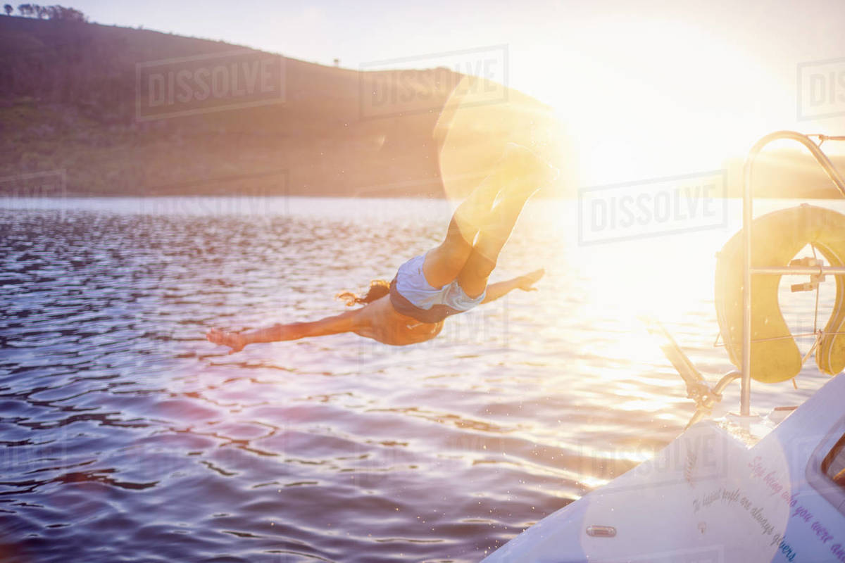 Woman jumping off boat into sunny ocean - Royalty-free Stock Photo ...