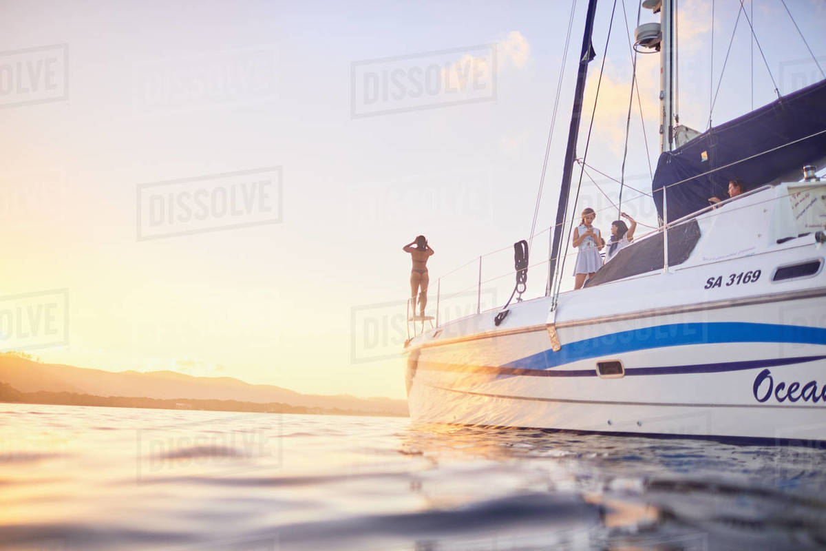 Friends on catamaran at sunset - Stock Photo - Dissolve