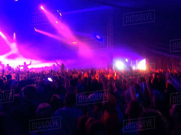 Crowd facing illuminated stage - Stock Photo - Dissolve