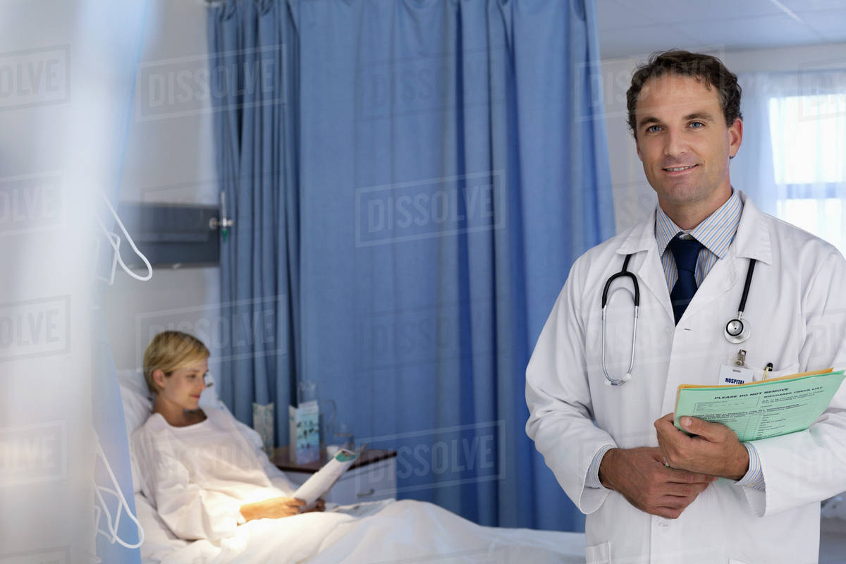 Doctor smiling in hospital room - Stock Photo - Dissolve