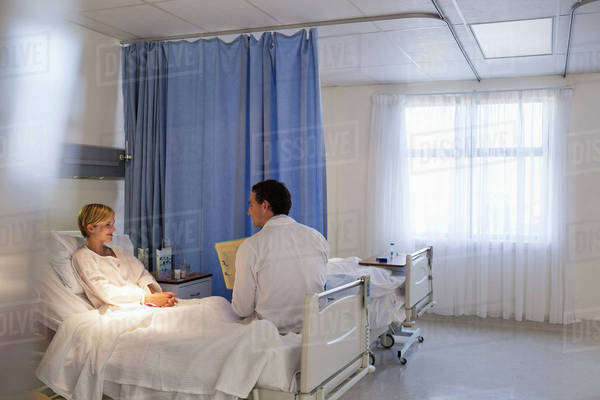Doctor talking with patient in hospital room - Royalty-free Stock Photo ...