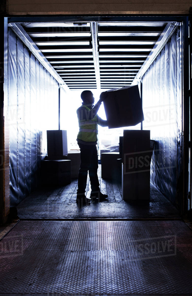 Worker stacking boxes in van - Stock Photo - Dissolve