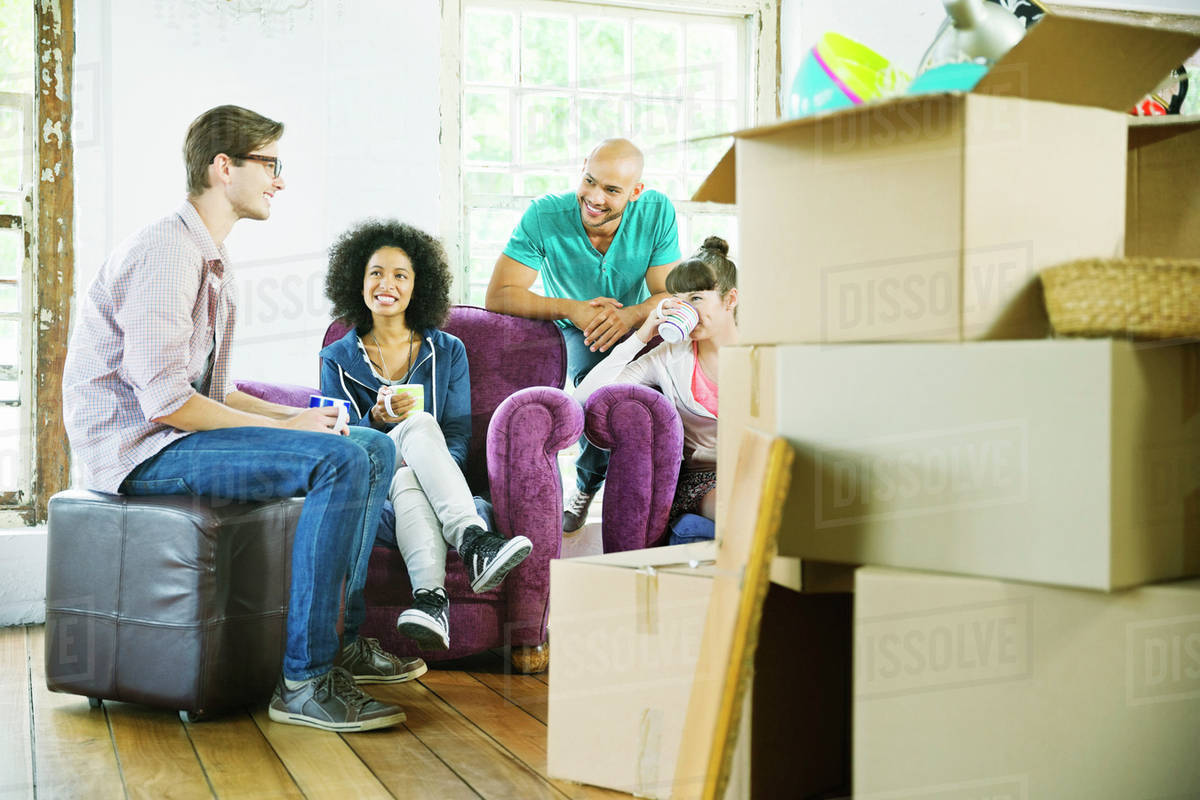 Friends relaxing together in new home - Stock Photo - Dissolve