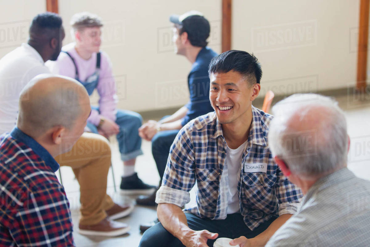Men talking and listening in group therapy - Stock Photo - Dissolve