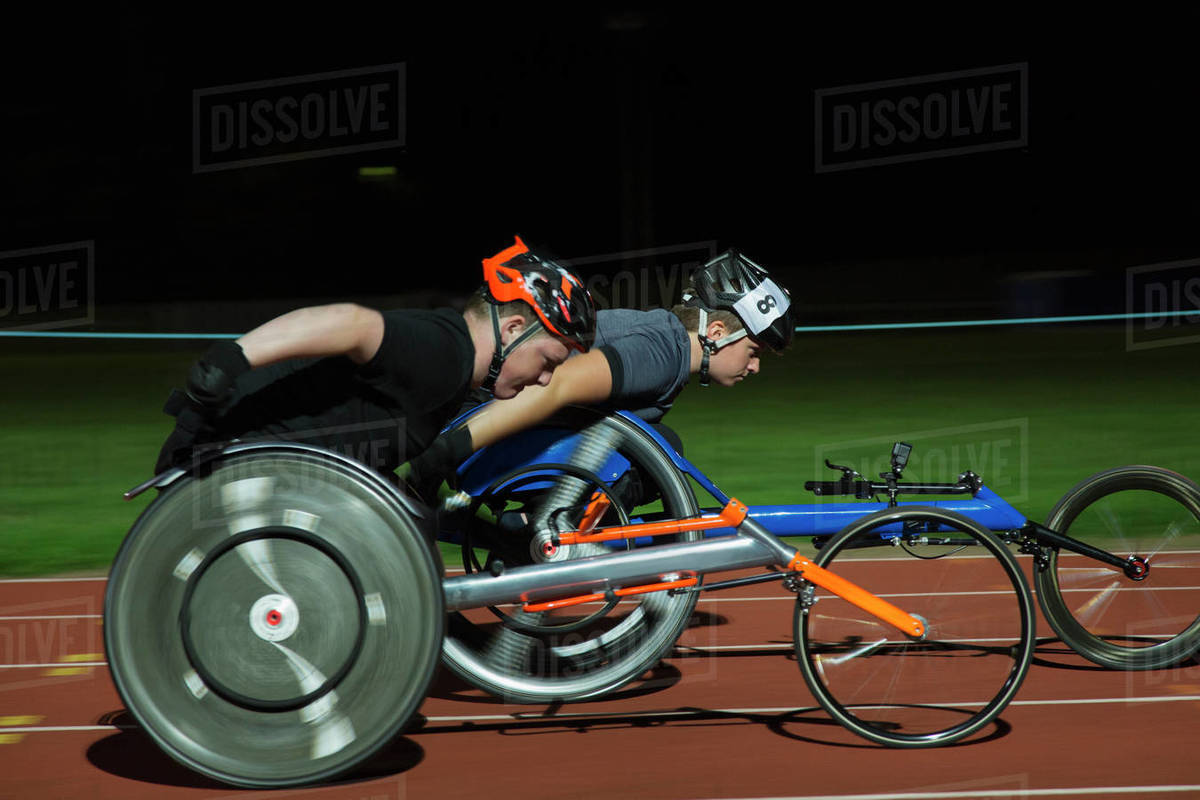 Paraplegic athletes speeding along sports track during wheelchair race ...