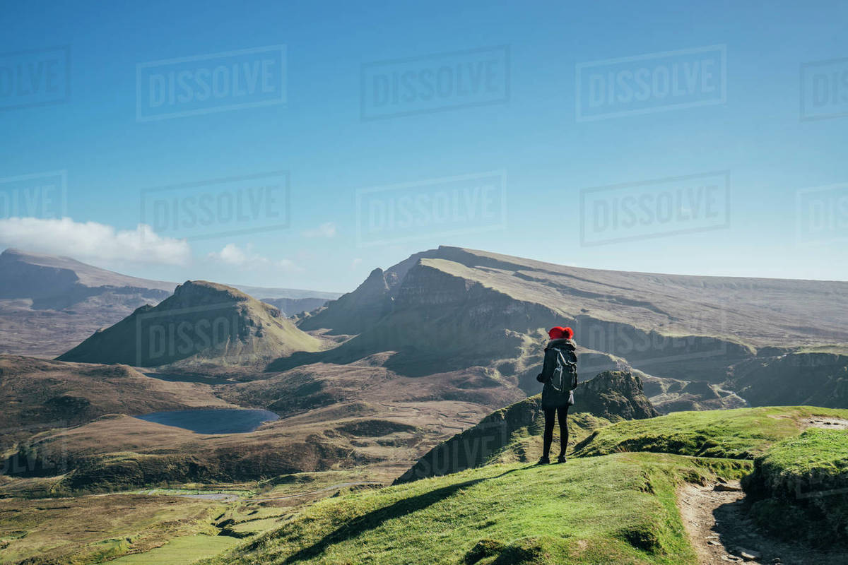 Female hiker looking at sunny landscape view, Isle of Skye, Scotland ...