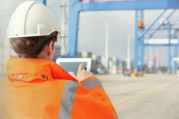 Female dock worker using digital tablet at shipyard - Royalty-free ...