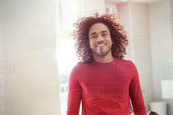 Portrait confident, smiling young man with curly hair - Stock Photo ...
