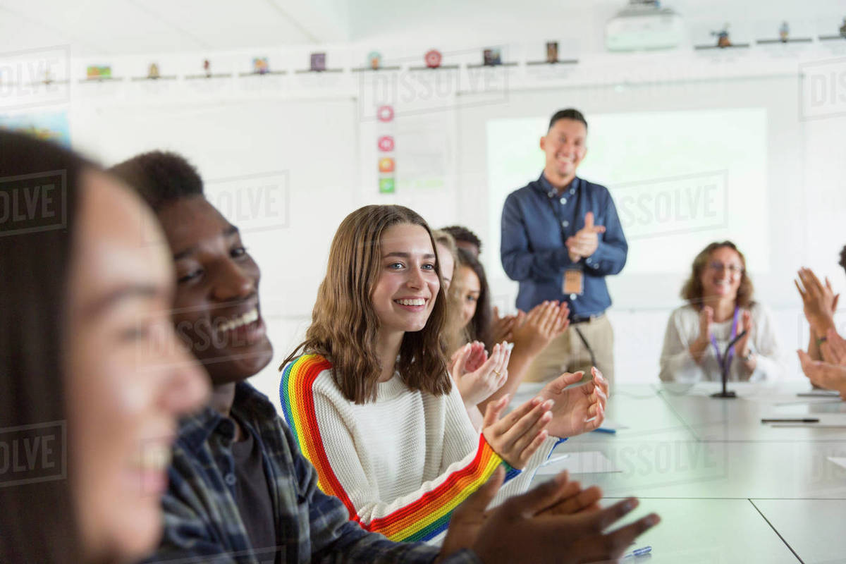 Happy high school students and teacher clapping in debate class ...
