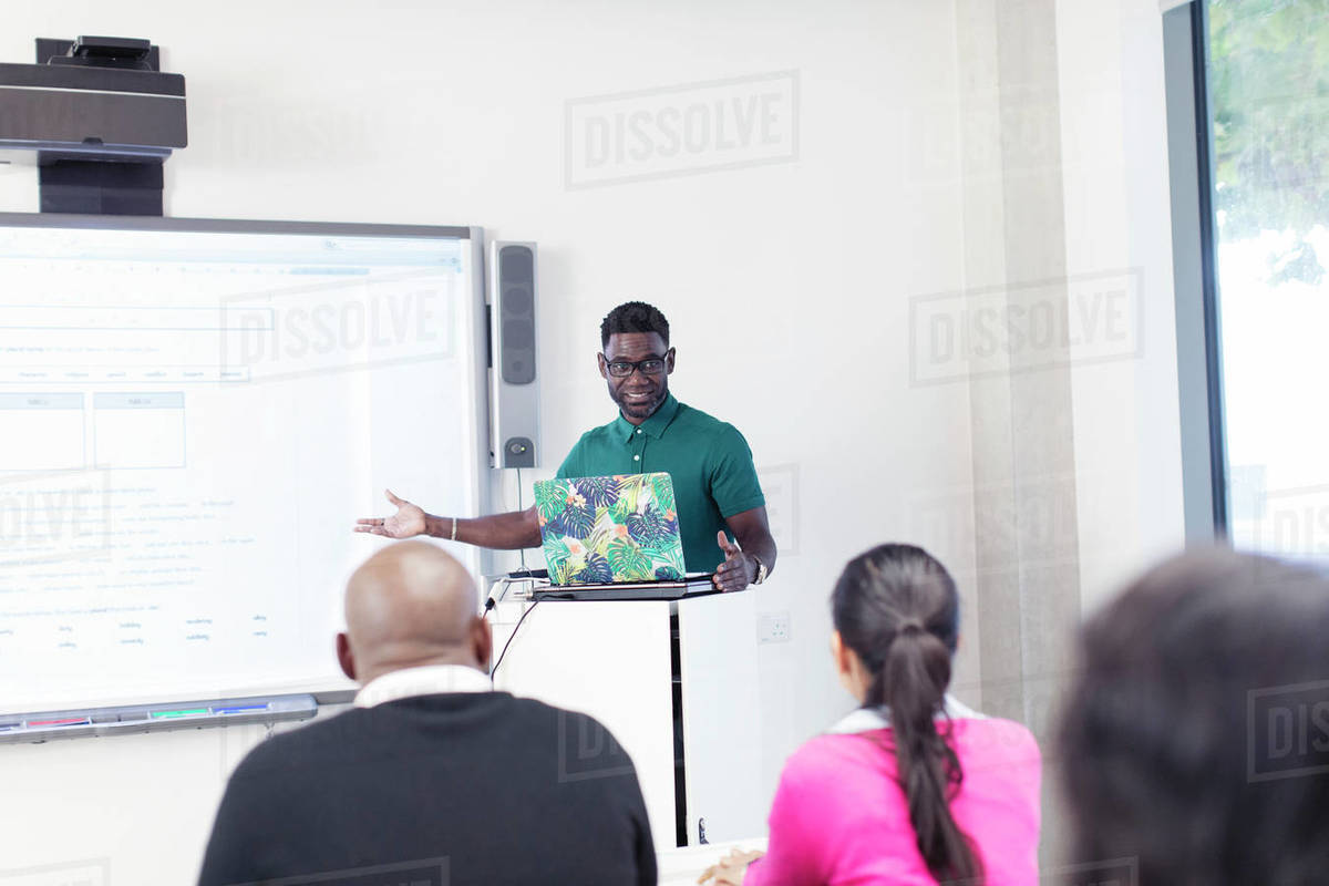 Male community college instructor teaching lesson at laptop and ...