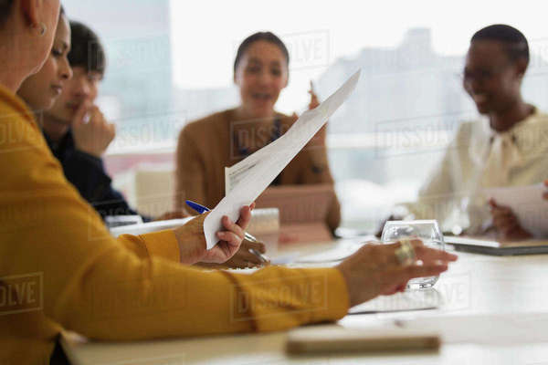Business people discussing paperwork in conference room meeting ...